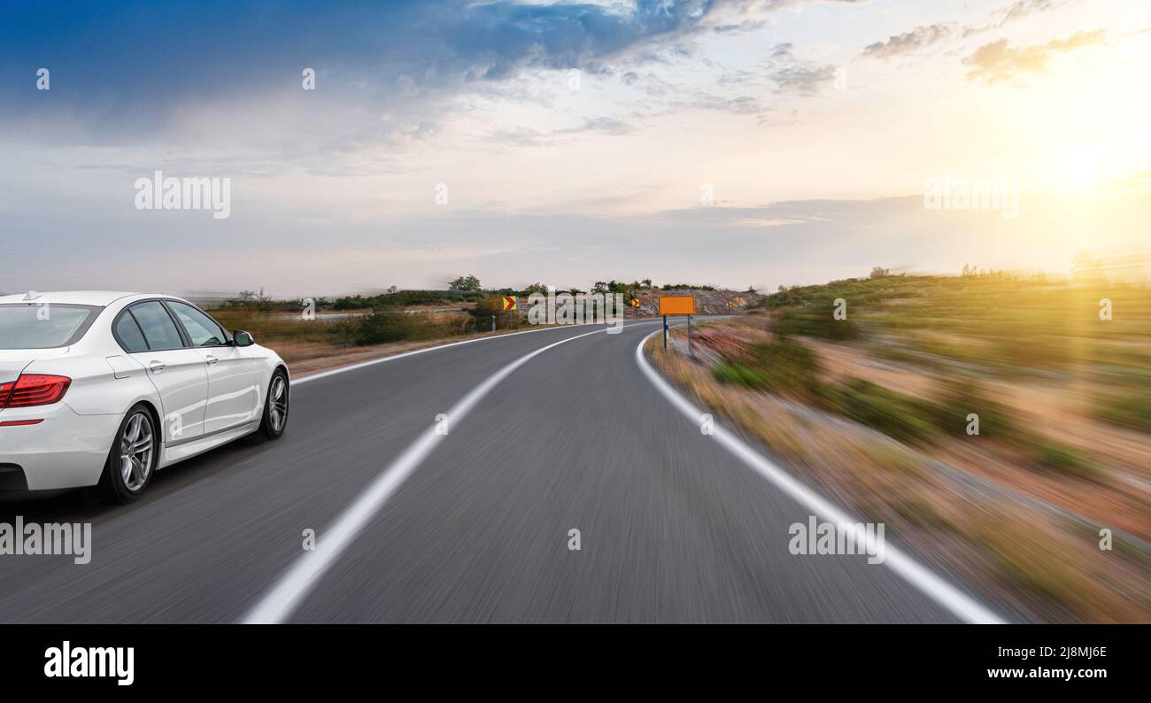 Blue car drives along road hi-res stock photography and images - Alamy