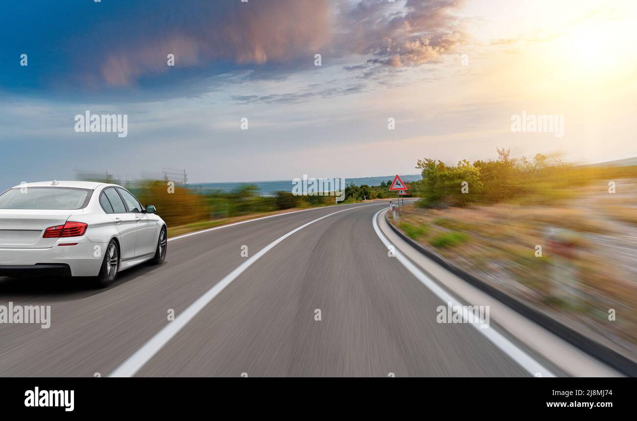 A white car drives along a beautiful road Stock Photo - Alamy