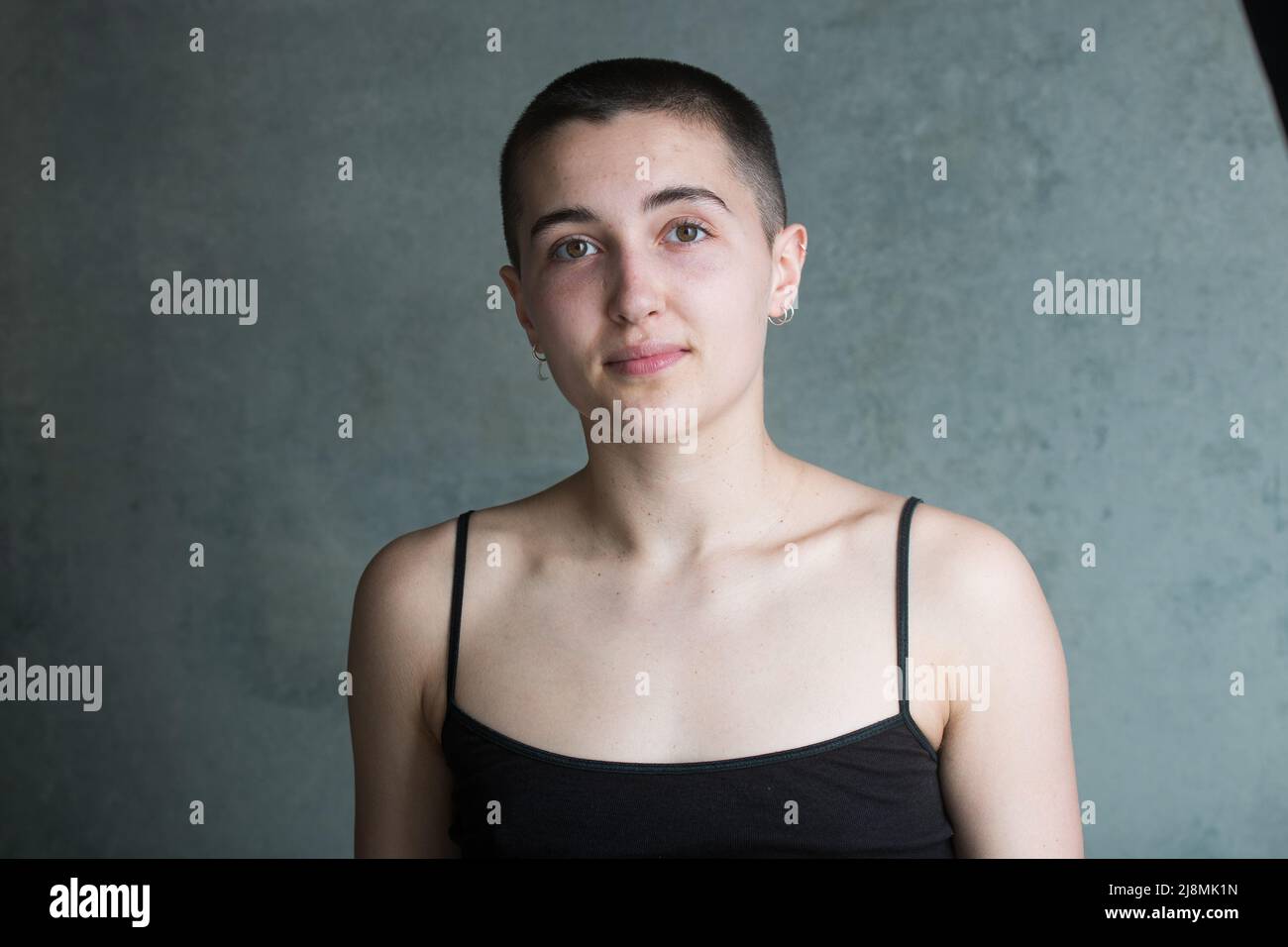 non-binary, they / them with shaved head and kind expression Stock ...