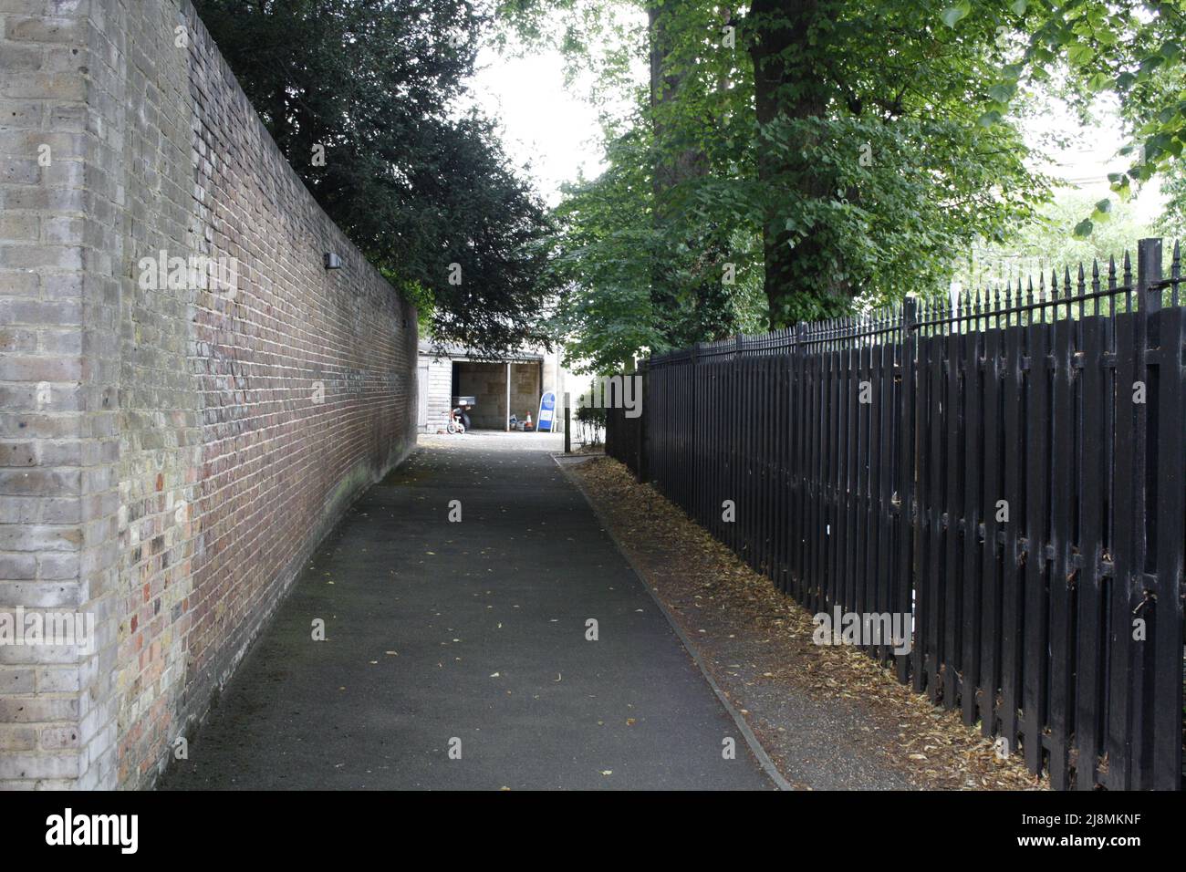 A path between the wall and a gate Stock Photo - Alamy