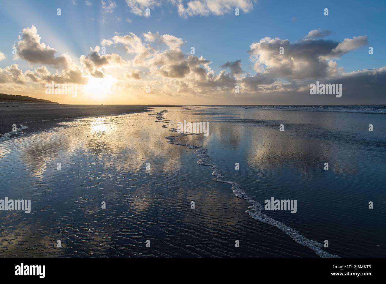 moody sunset at north sea with reflection in water Stock Photo - Alamy