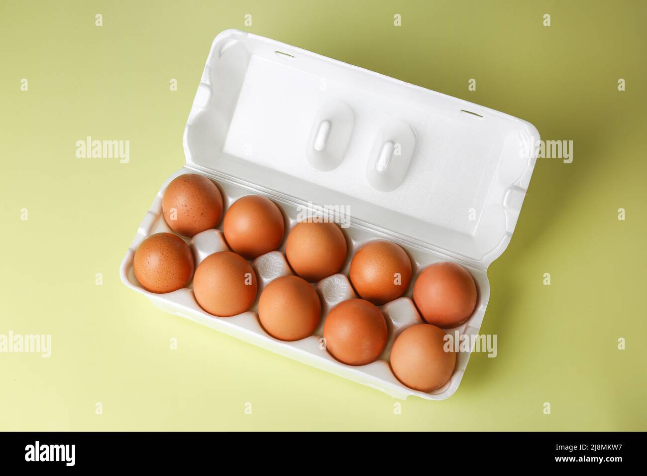 Brown eggs in expanded polystyrene packaging on an isolated light ...