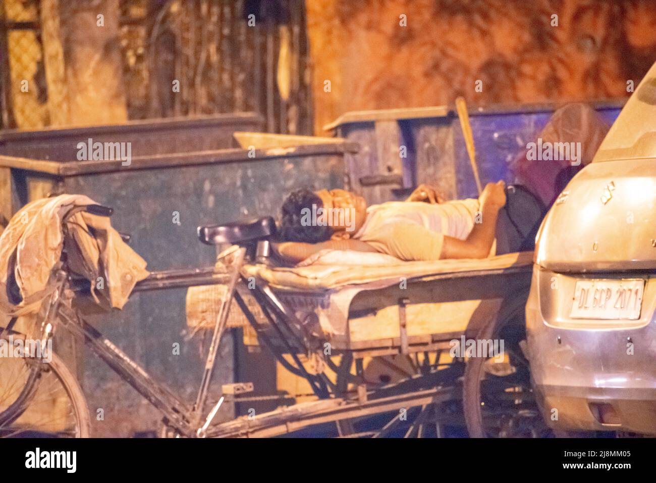 A homeless poor orphan boy is sleeping near the waste bin Stock Photo ...