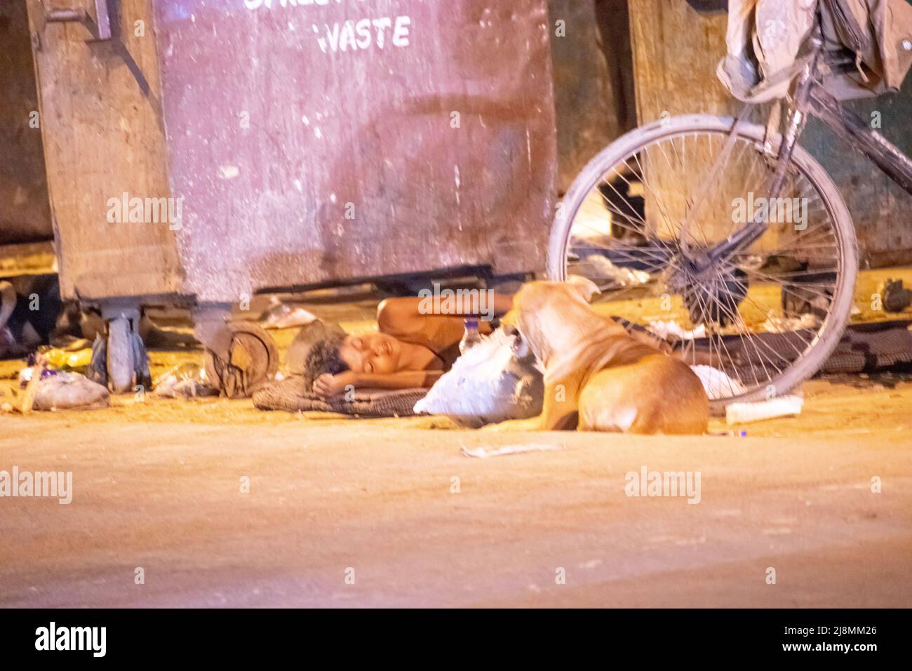 A homeless poor orphan boy is sleeping near the waste bin Stock Photo ...
