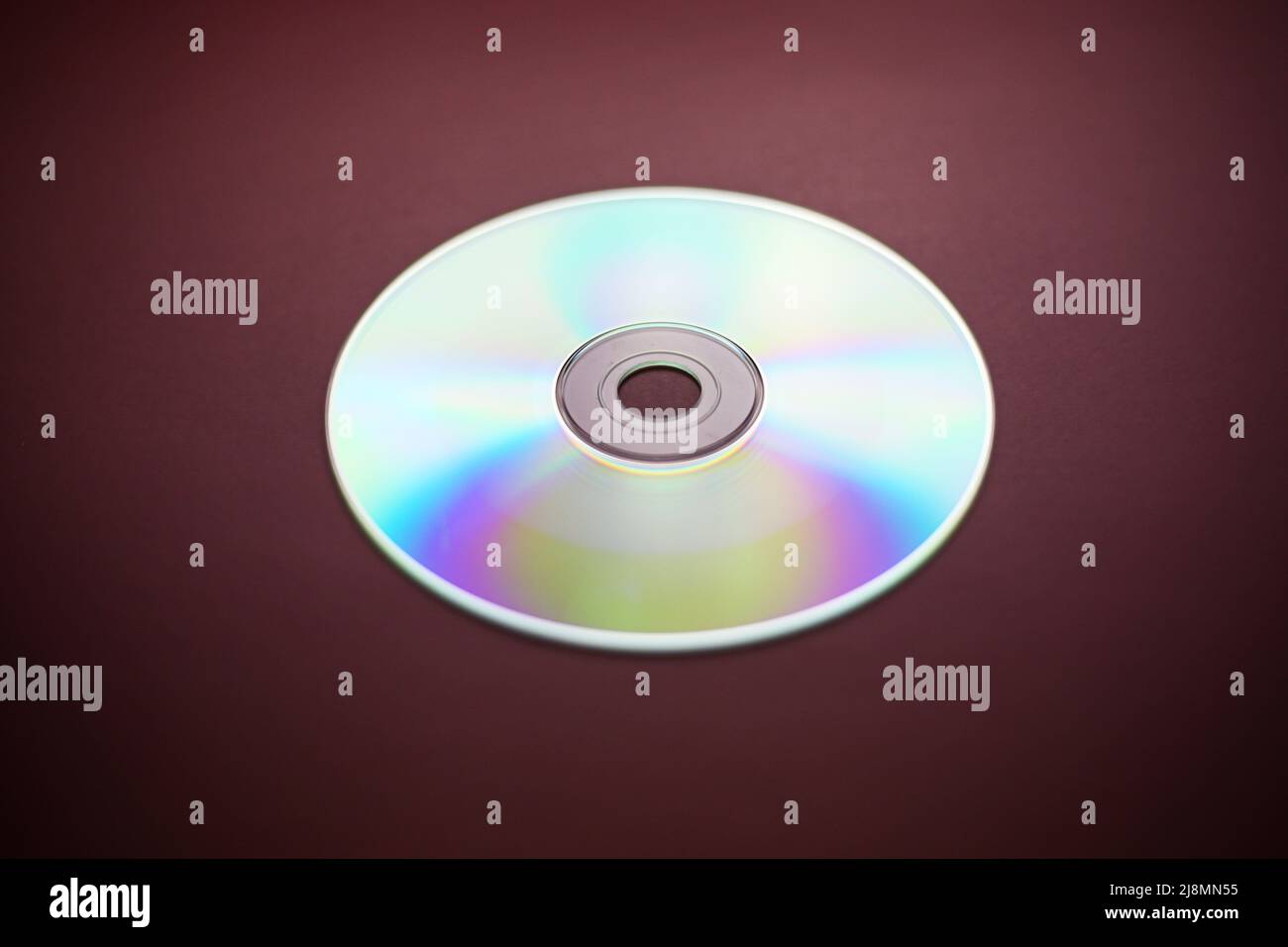 Compact disk close-up on a red burgundy background, outdated data ...