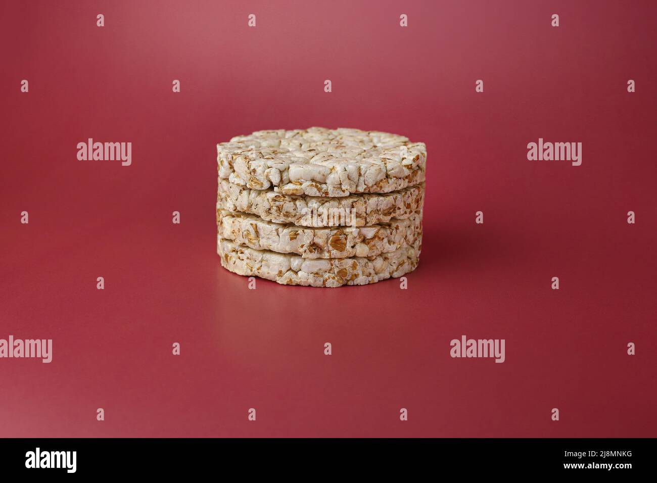 Rice buckwheat crispbread on an isolated background of Bordeaux color ...