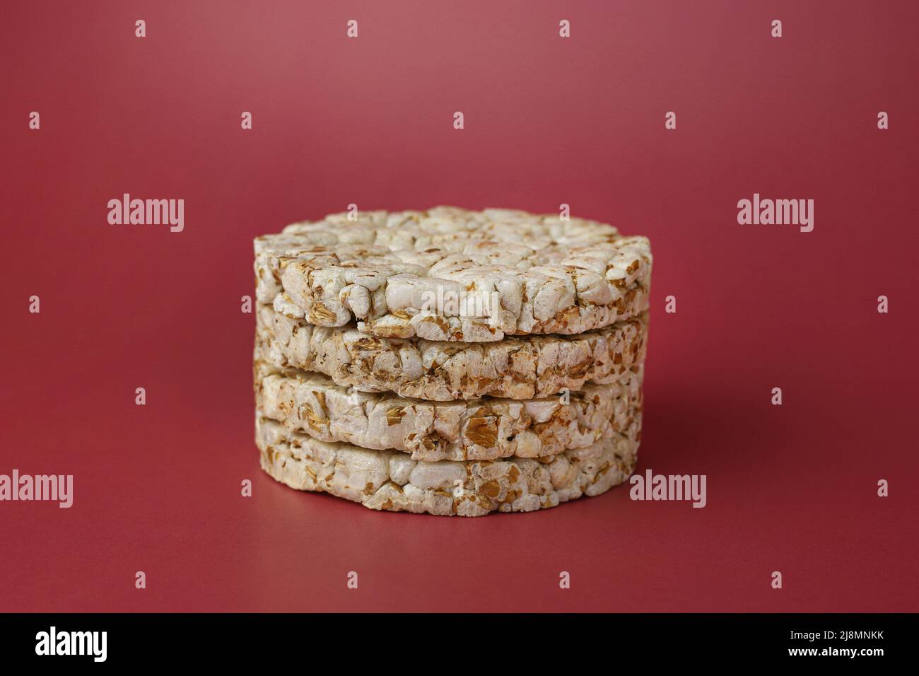 Rice buckwheat crispbread on an isolated background of Bordeaux color ...