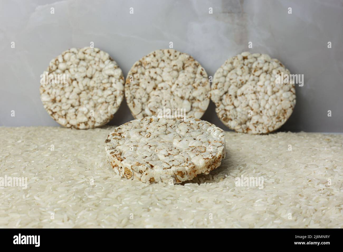 Standing rice buckwheat cake on a background of strewn rice groats ...