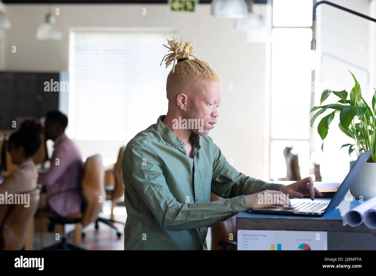 African american mid adult albino businessman using laptop while ...