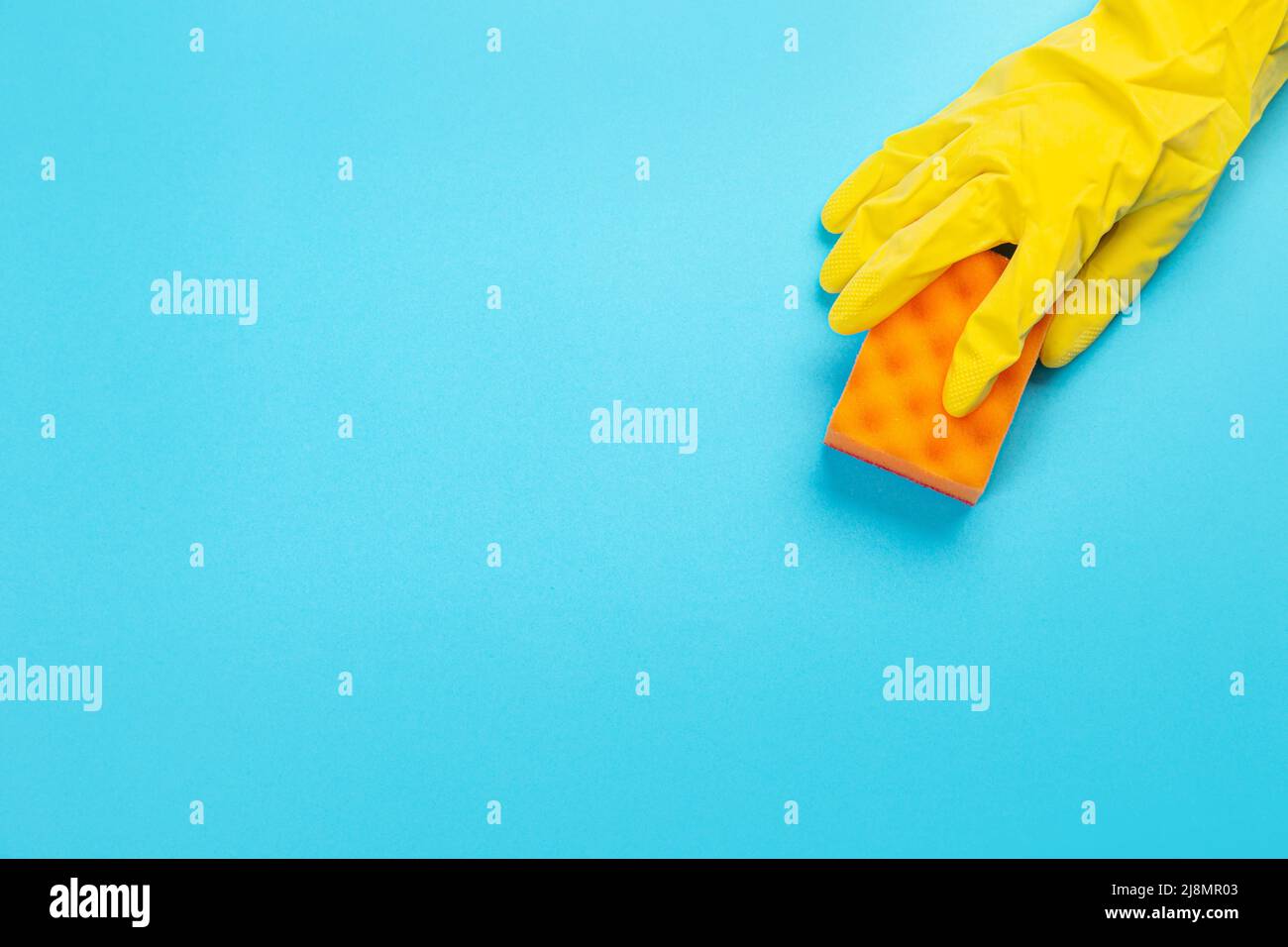 female hand in yellow rubber protective glove with micro fiber yellow ...