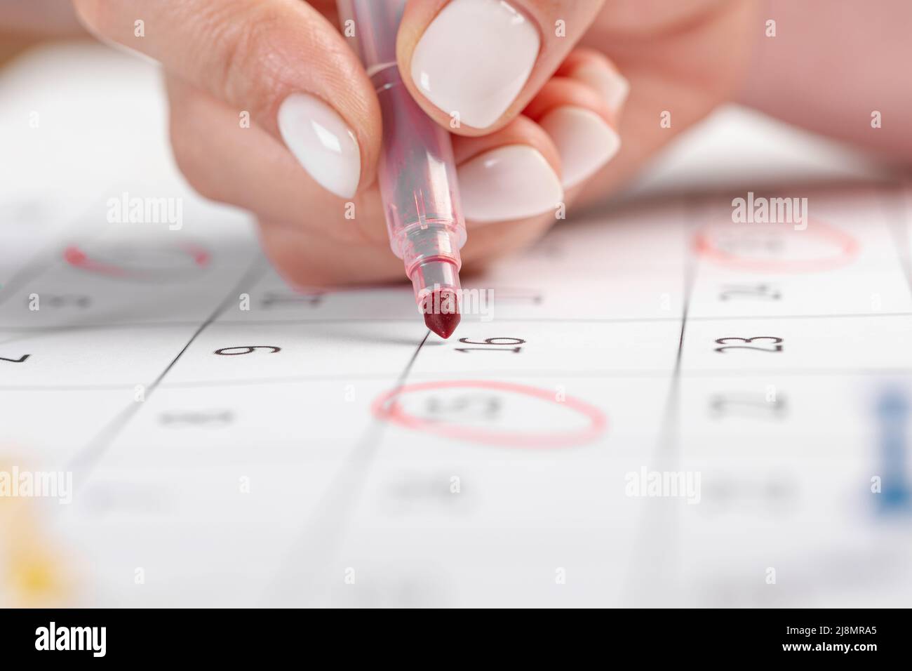 female hand marks with a red marker in the calendar notes an important ...