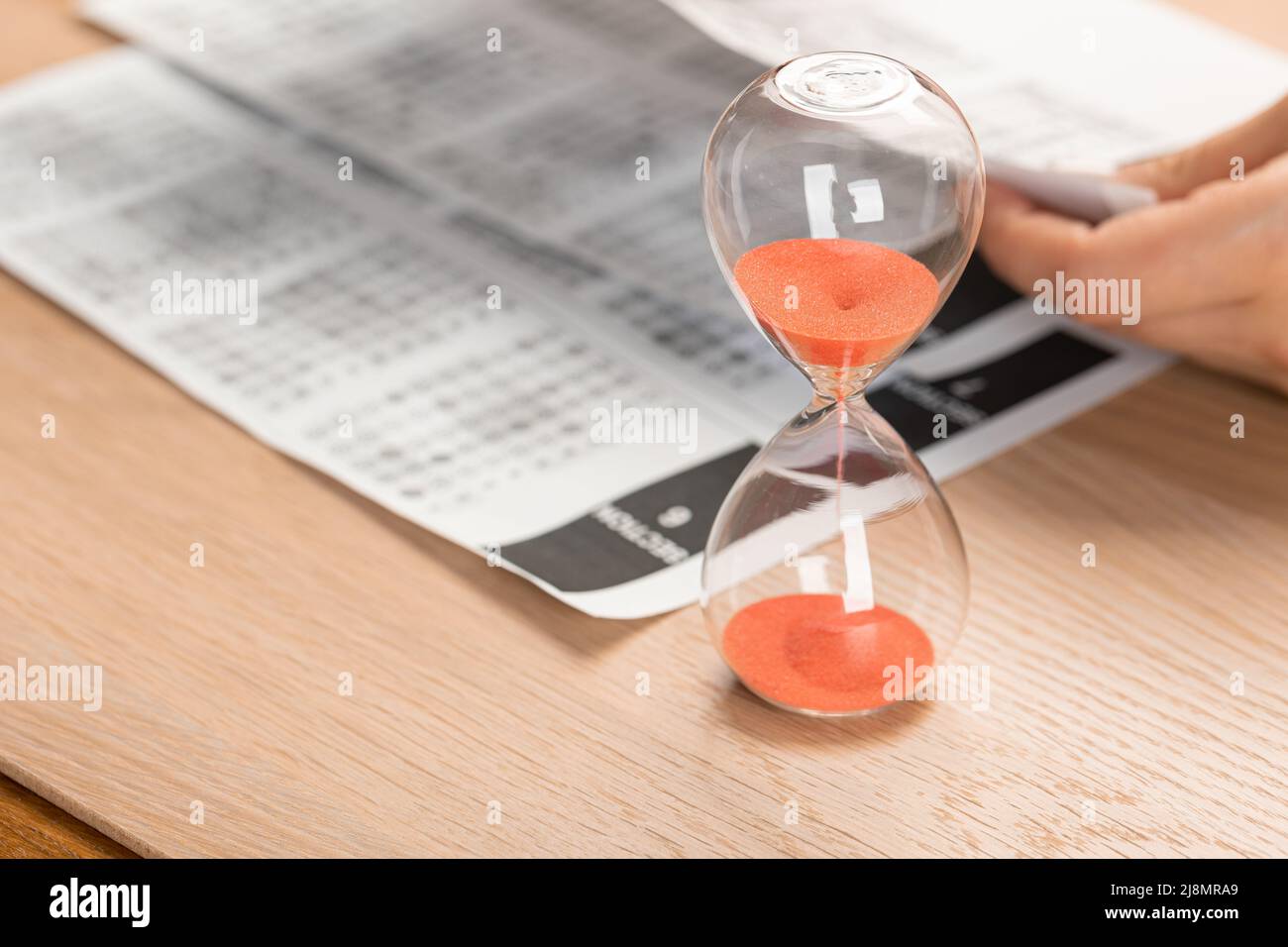 Hourglass with time running out and student hand testing in exercise ...