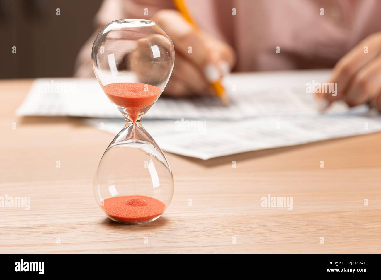 Hourglass with time running out and student hand testing in exercise ...