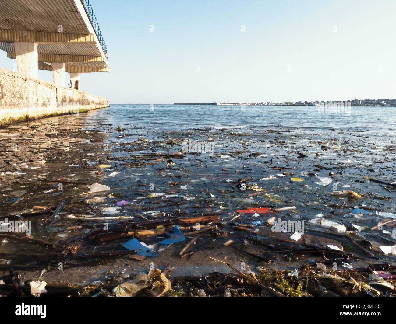 Plastic debris on blue sea surface. Polluted beach. Garbage, bottles ...