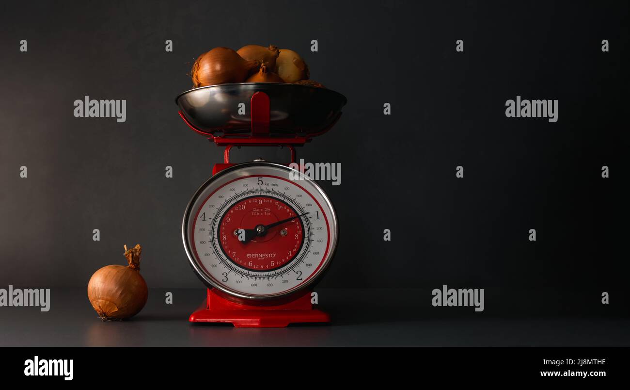 Onions in an old kitchen scale on a grey background Stock Photo - Alamy