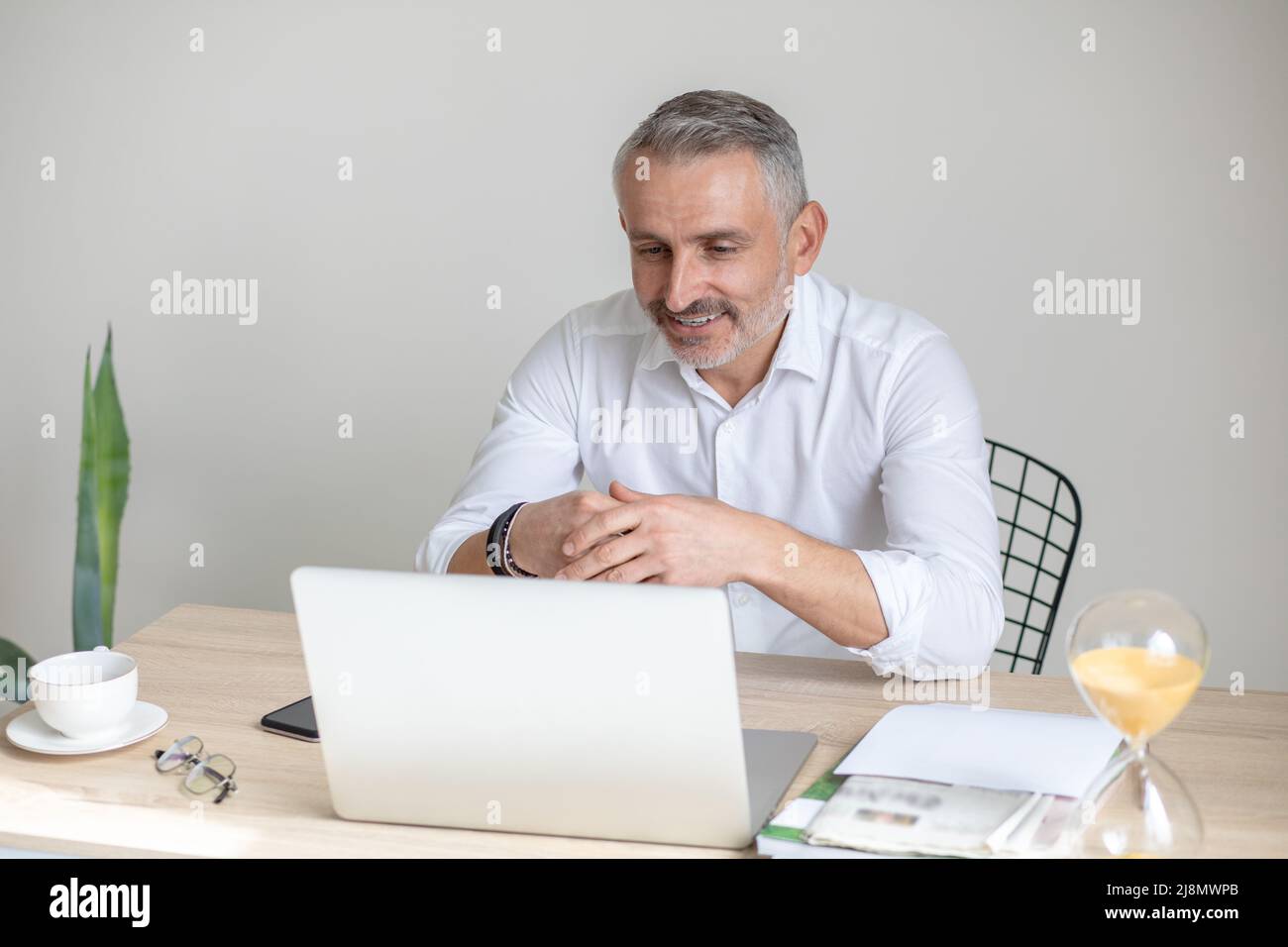 Man talking on video call smiling at laptop screen Stock Photo - Alamy