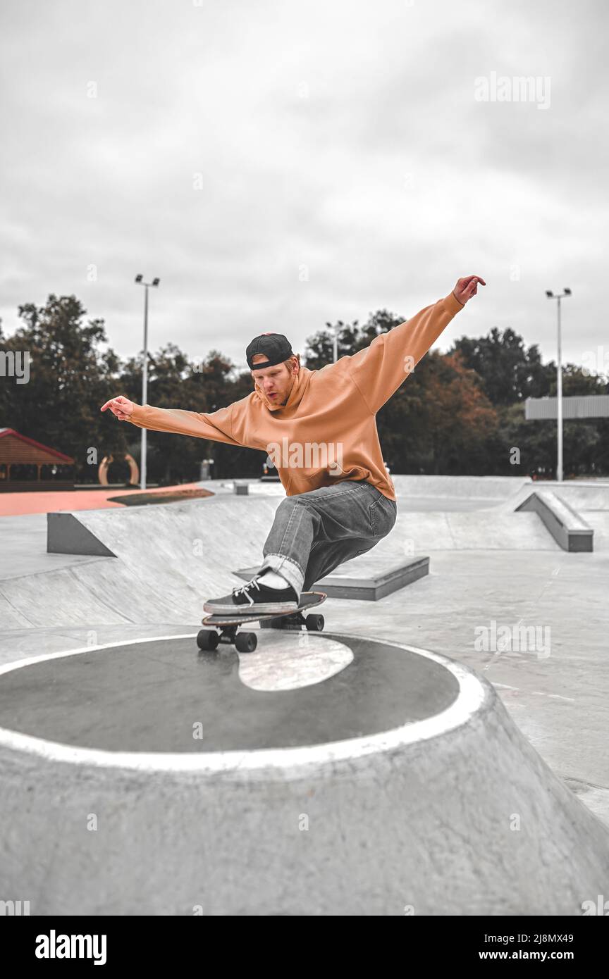 Guy on skateboard riding on pedestal in skatepark Stock Photo - Alamy