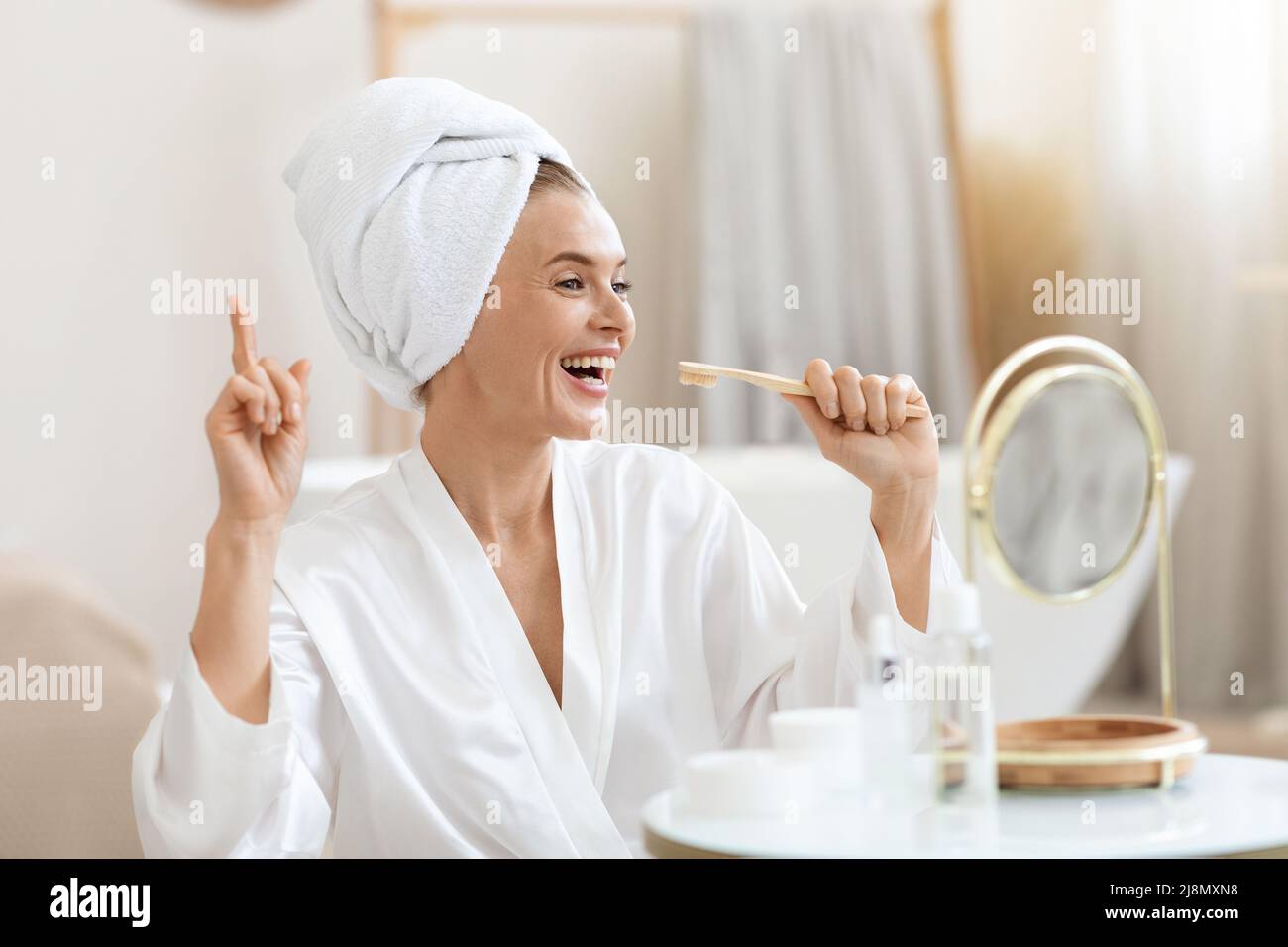 Happy adult woman brushing her teeth and singing Stock Photo - Alamy
