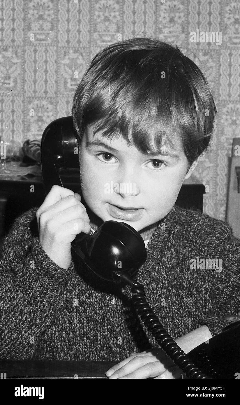 1970s, historical, a little boy holding the handset of a telephone of ...