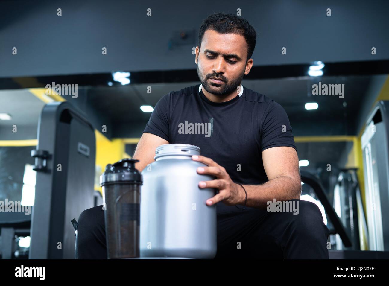 bodybuilder drinking or taking protein powder and mixing with water on ...