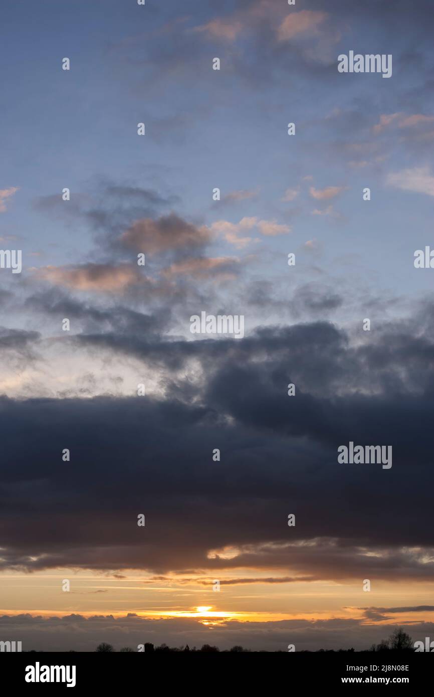 Winter sunset with golden light breaking through dramatic stratocumulus ...