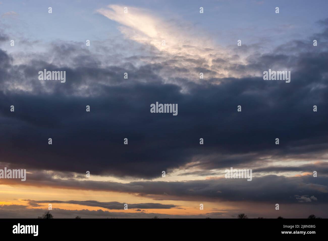 Winter sunset with golden light breaking through dramatic stratocumulus ...