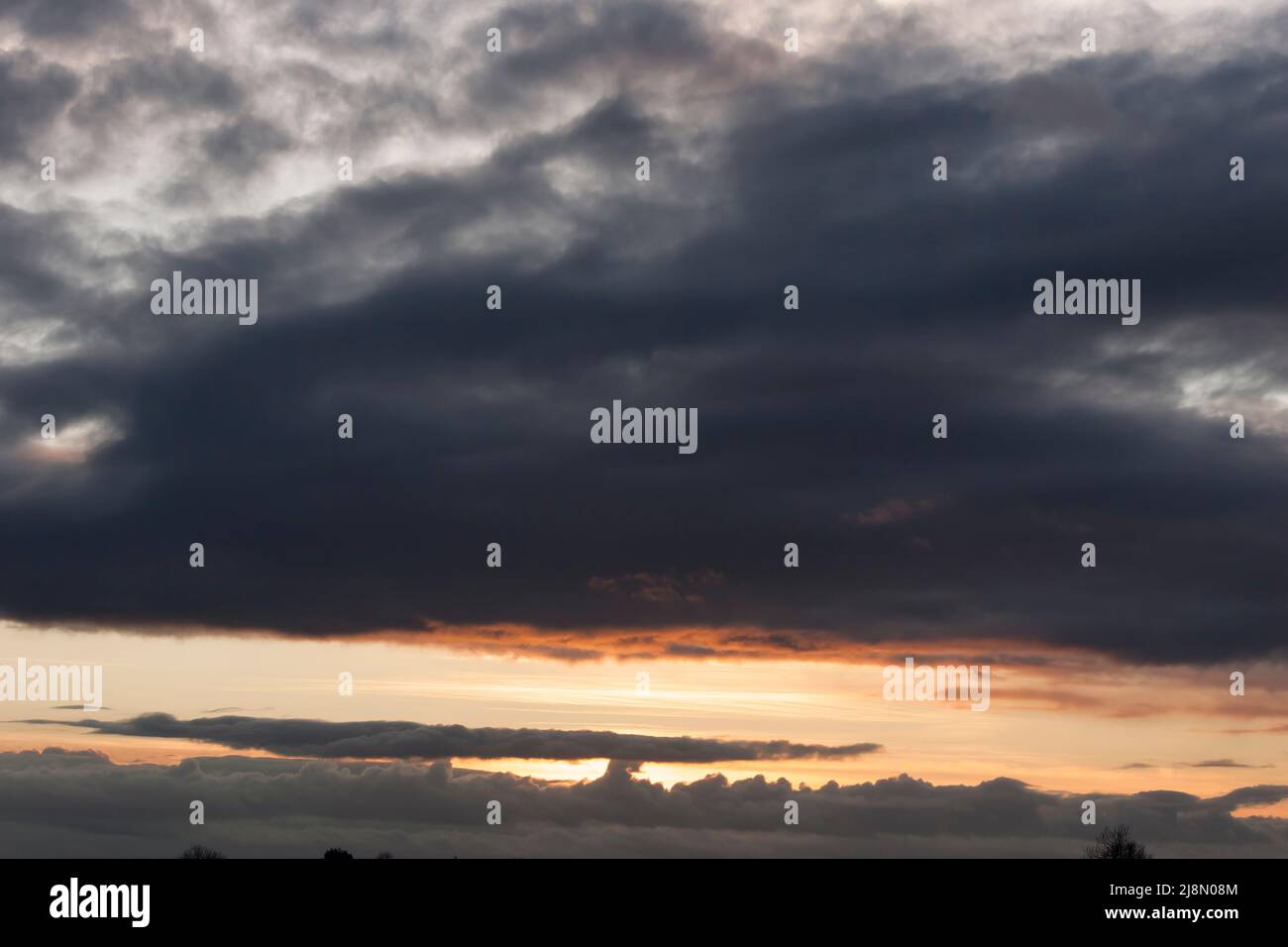 Winter sunset with golden light breaking through dramatic stratocumulus ...