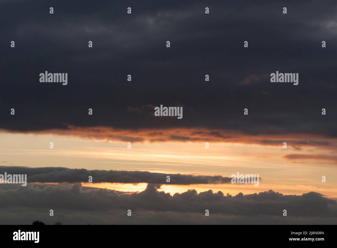 Winter sunset with golden light breaking through dramatic stratocumulus ...