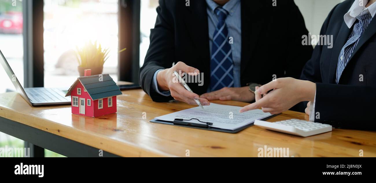 Real estate agent with house model hand putting signing contract,have a ...