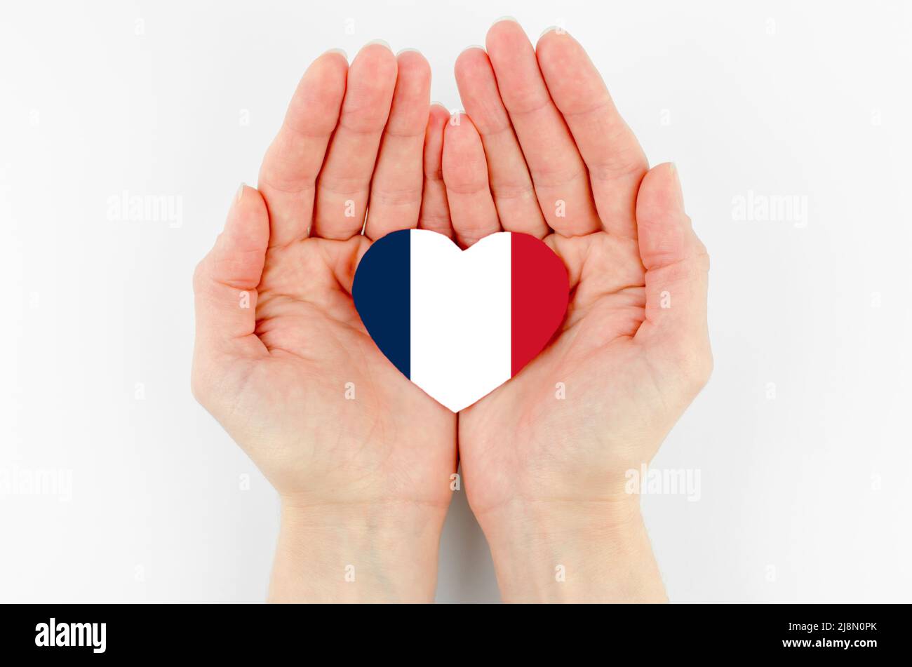 Flag of France in the shape of a heart in female palms on a white ...