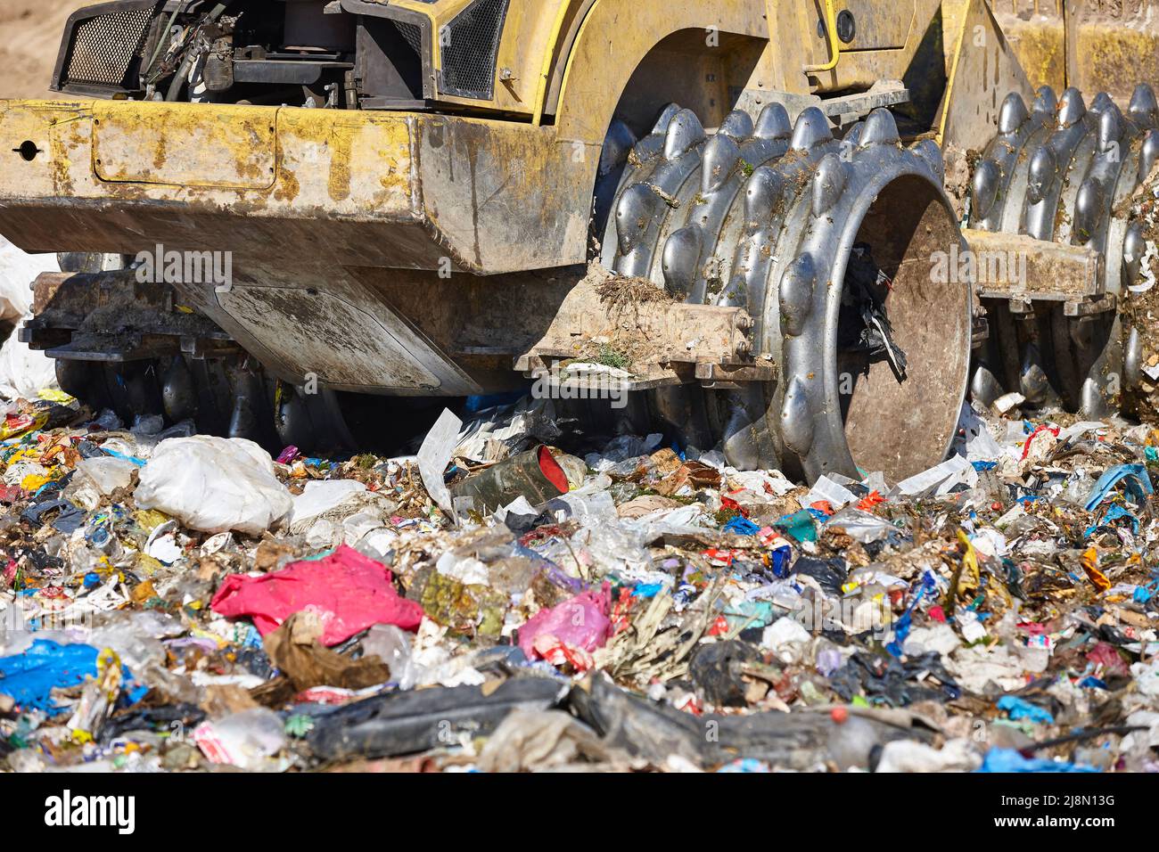 Heavy machinery shredding garbage in an open air landfill. Waste Stock ...