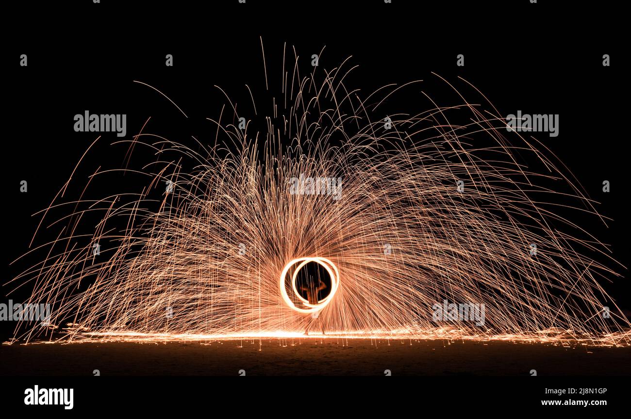 Firestarter performing amazing fire show with sparkles in the night ...