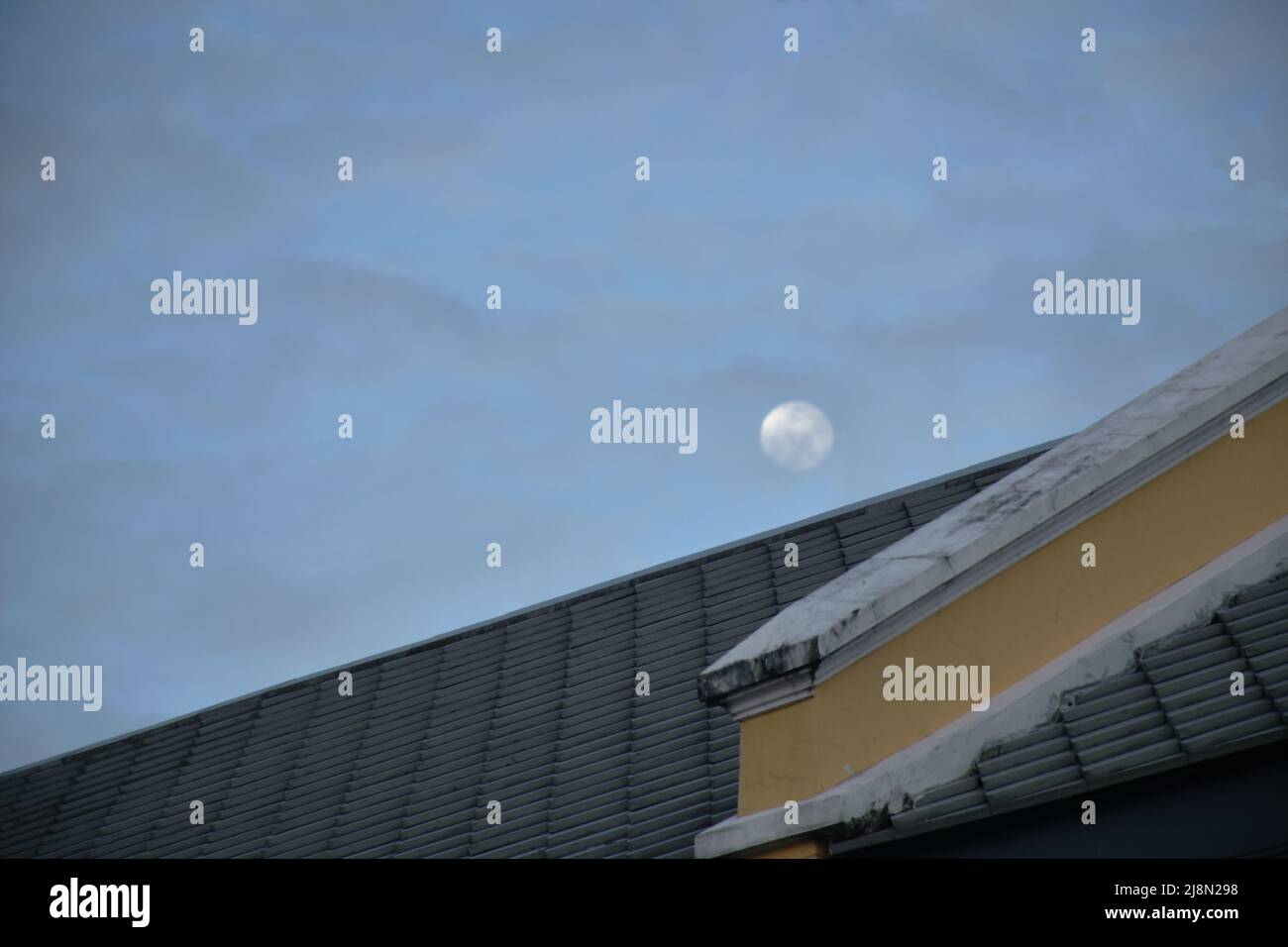moon over home rooftop in sky on evening Stock Photo - Alamy