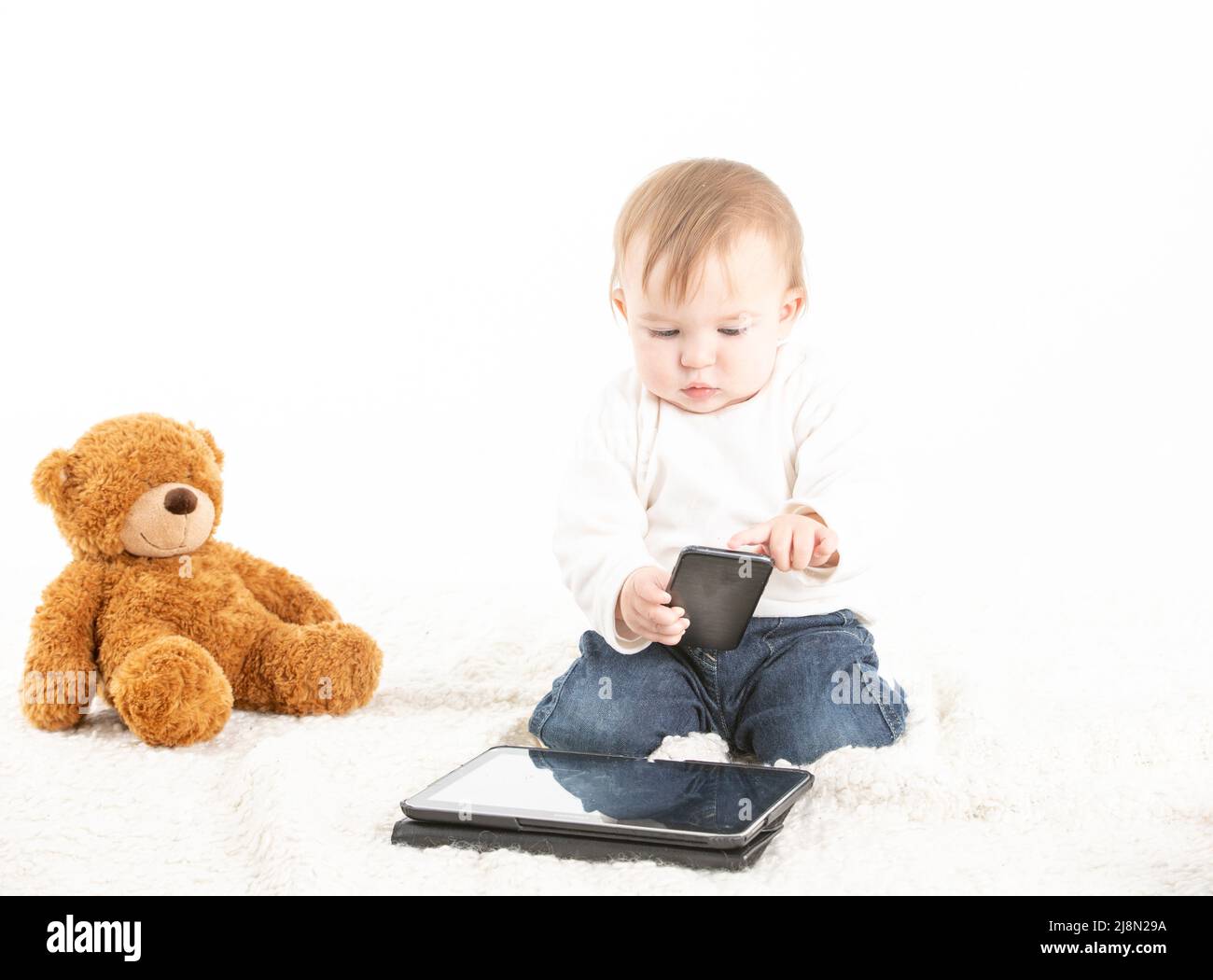 Stock studio photo with a white background of a baby with a mobile in ...