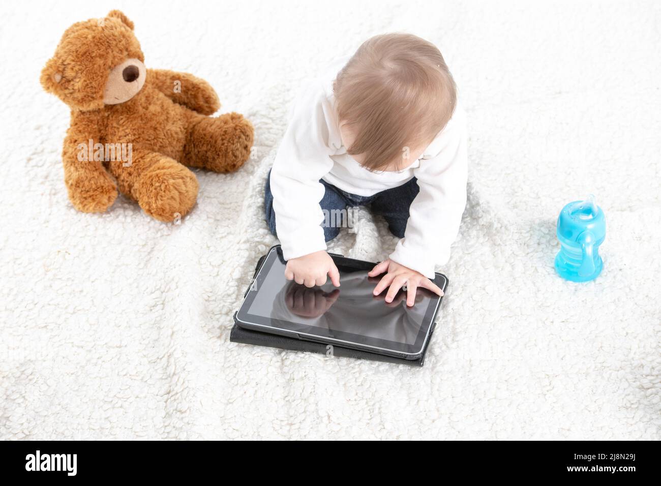 Stock aerial studio photo with the white background of a baby touching ...