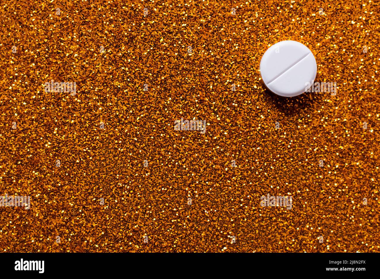 top view of white pill on shiny brown gold background Stock Photo - Alamy