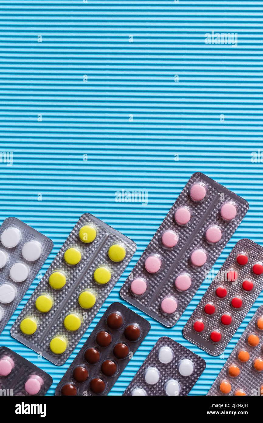top view of blister packs with different pills on blue textured ...