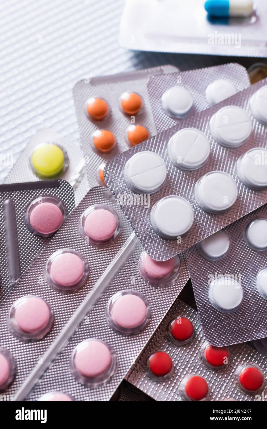 top view of blister packs with different colorful pills on white ...
