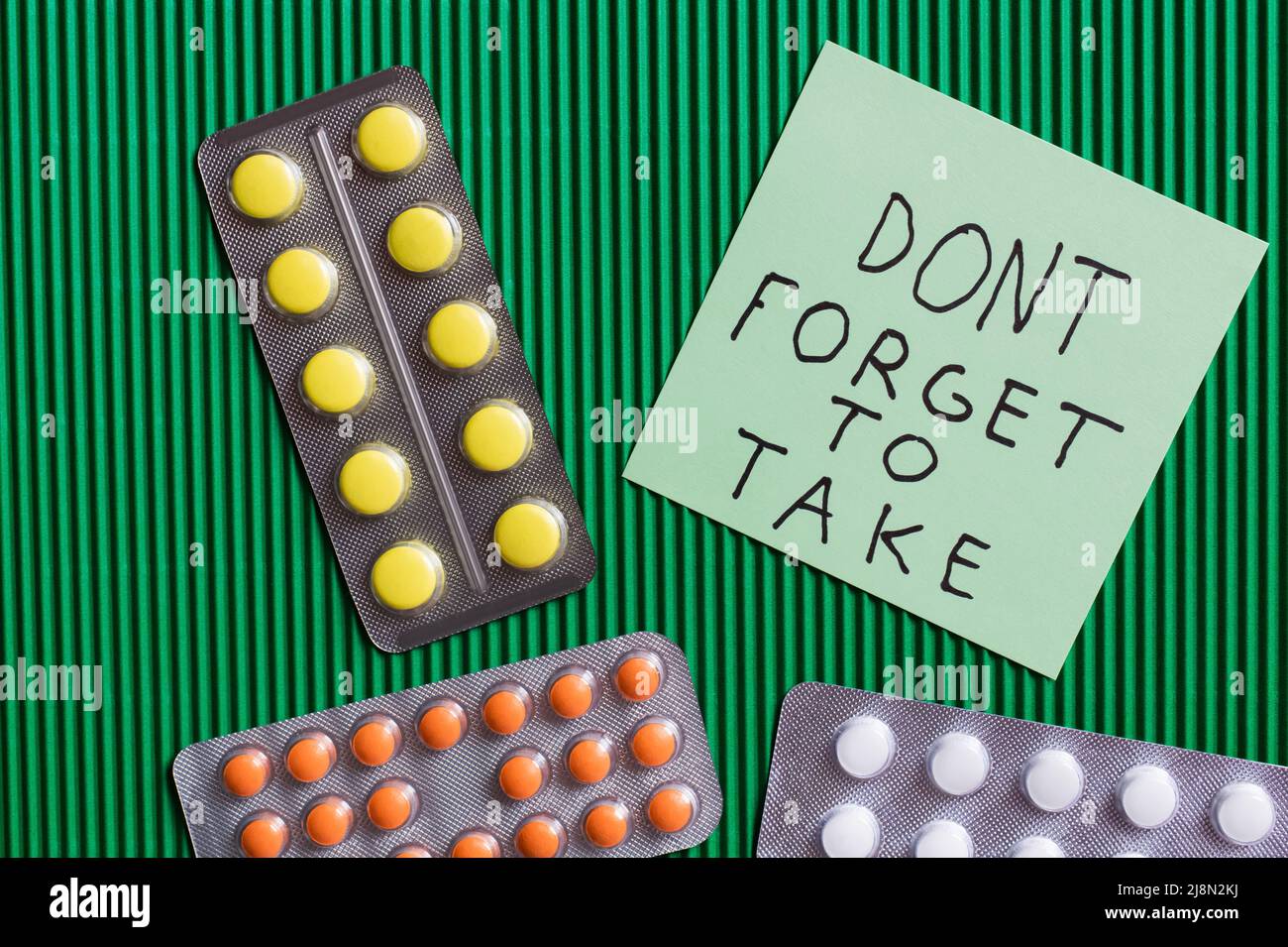 top view of blister packs with pills near paper note with dont forget ...