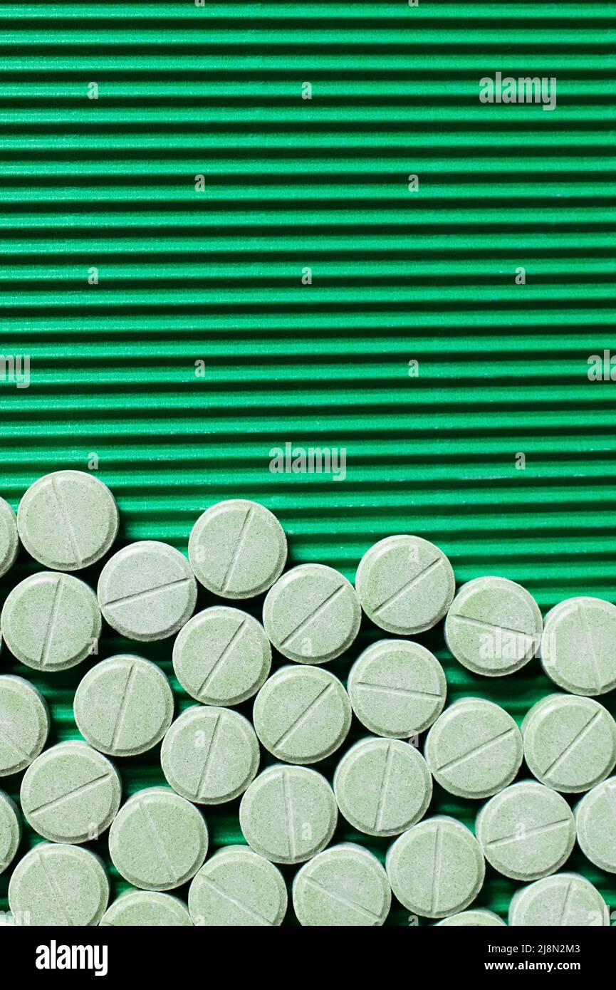 top view of round shape medication on textured green background Stock ...