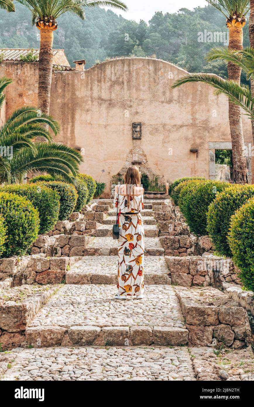 Female tourist standing on steps amidst plants in historic park against ...