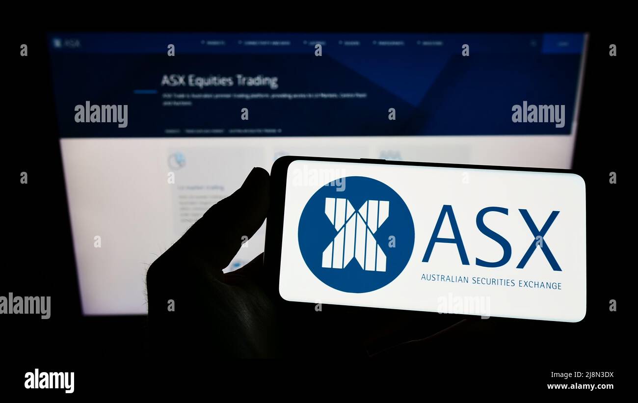 Person holding smartphone with logo of Australian Securities Exchange ...