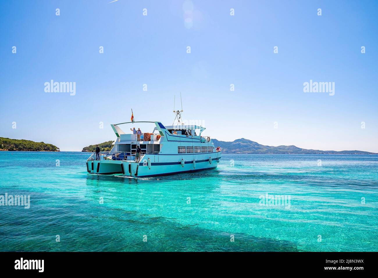 Tourists sailing on yacht turquoise sea against clear blue sky during ...