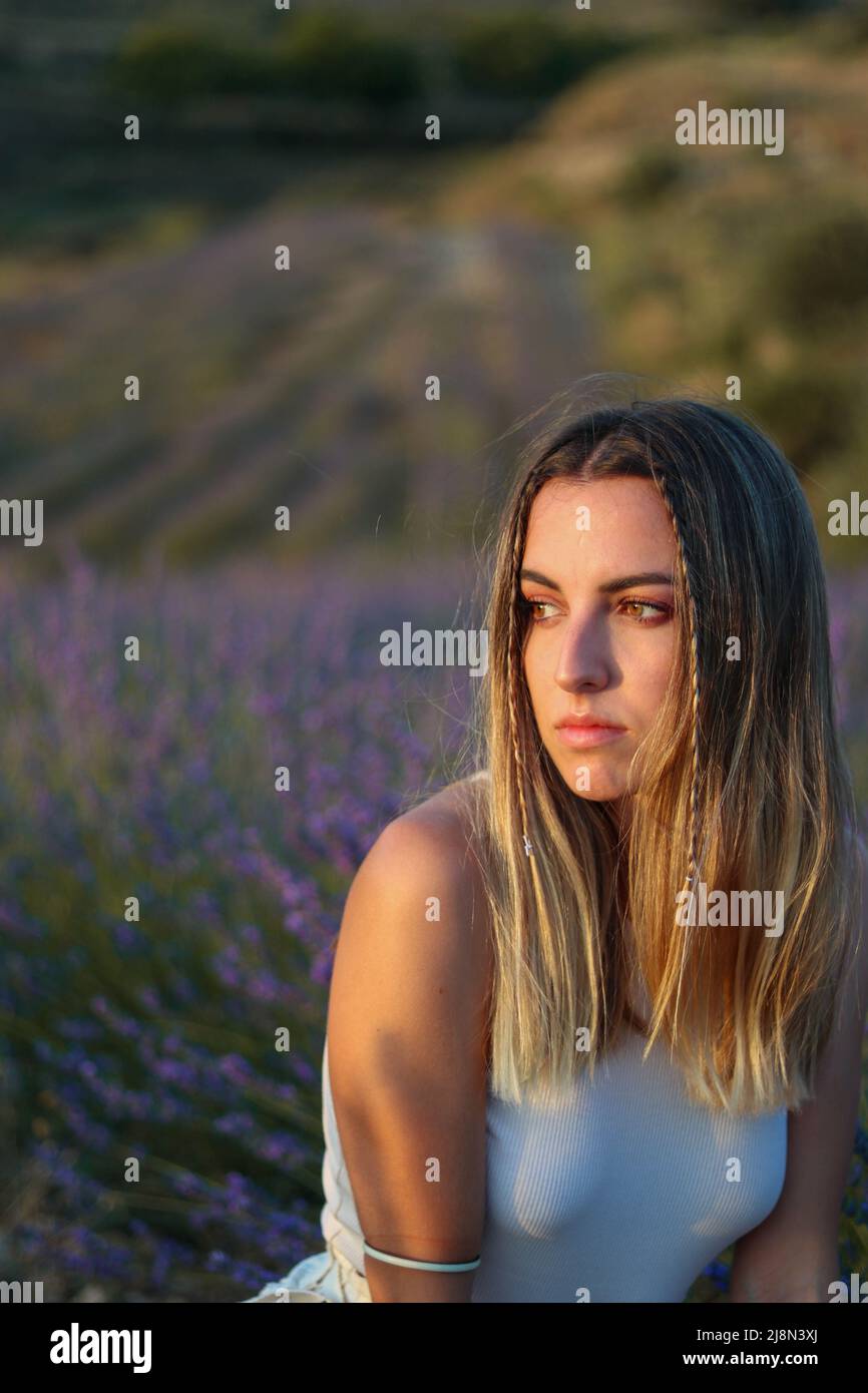 Portrait of pretty young woman posing and gazing in the evening light ...