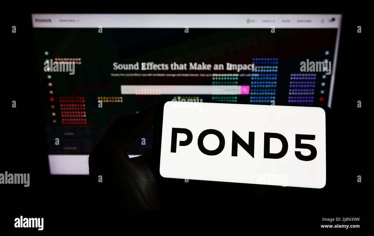 Person holding cellphone with logo of US media marketplace company ...