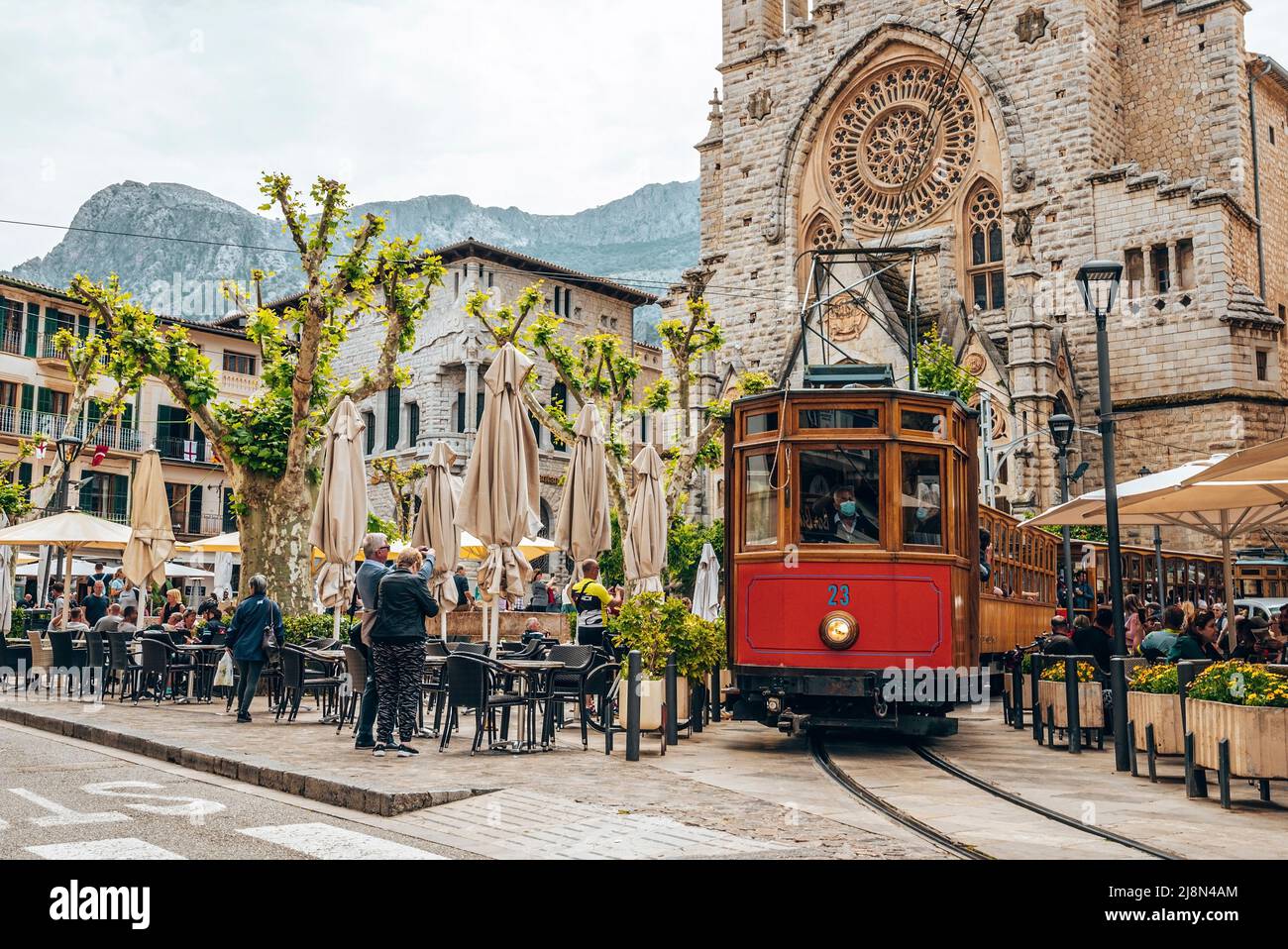 Tourists sightseeing while tram moving on rail tracks against church in ...