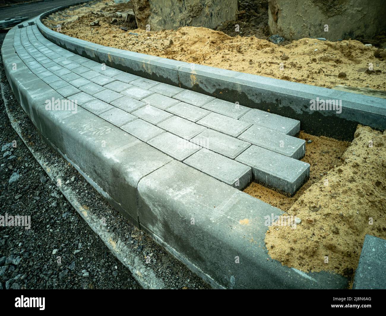 Construction of a sidewalk from paving slabs and concrete curbs Stock ...