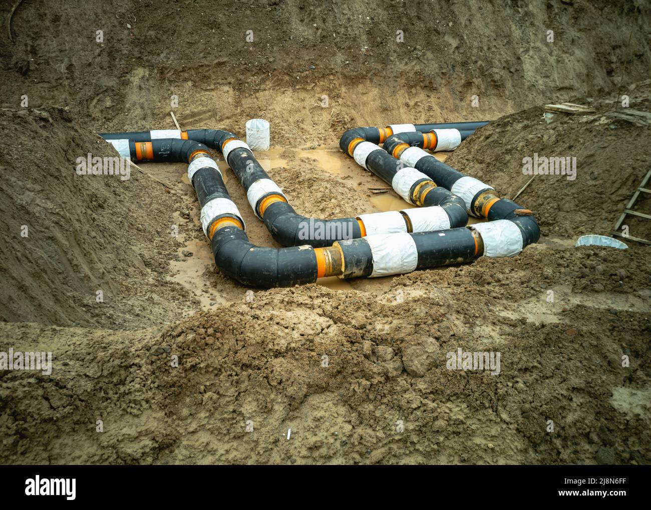 Water pipes for supplying communications lie in a trench dug in the ...