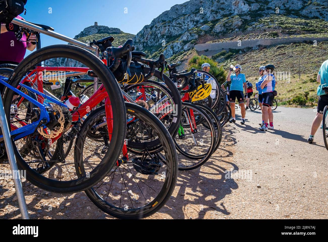 Cyclists taking rest by parked bicycles against mountain during ...