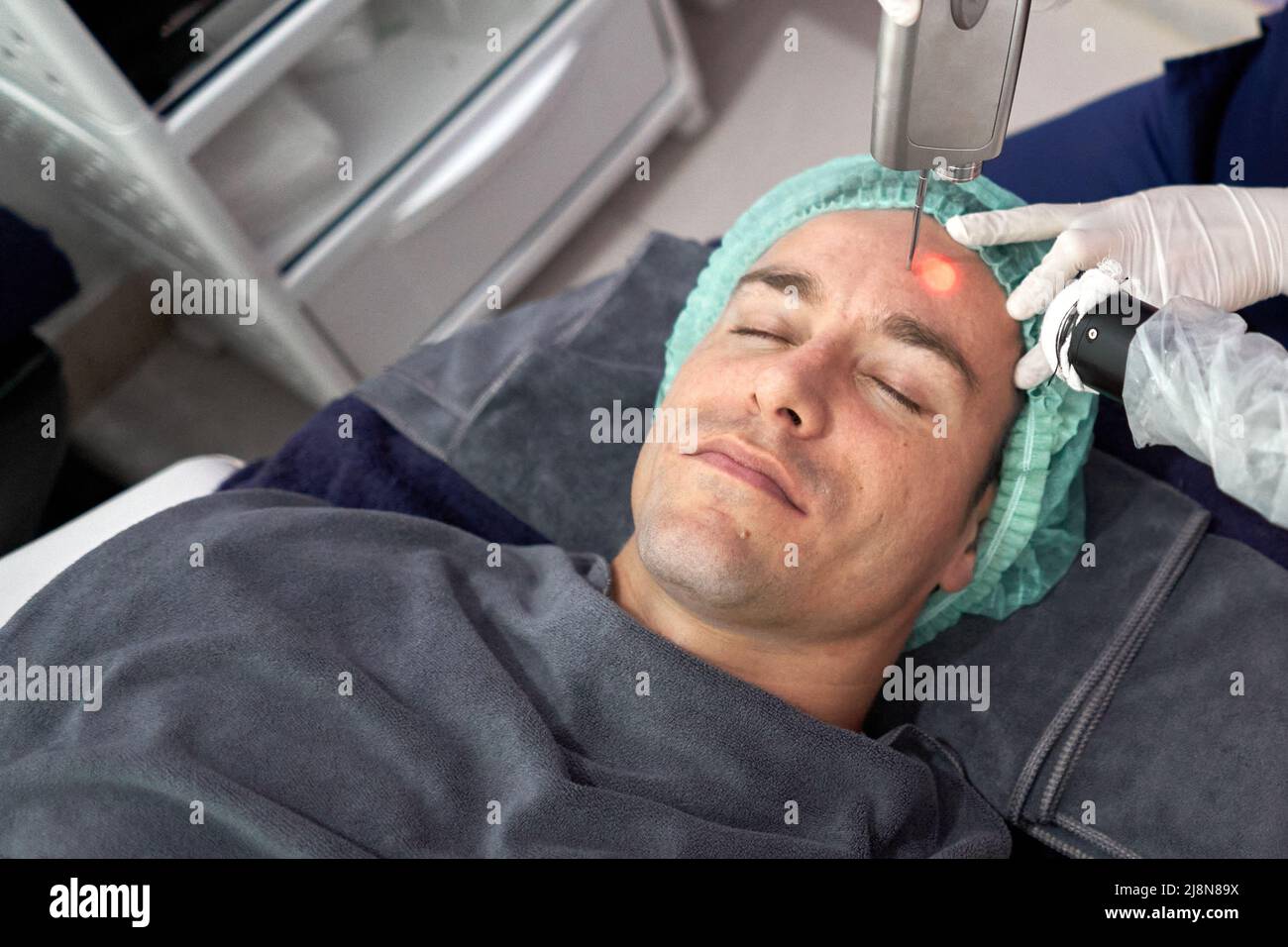 Relaxed man receiving a laser treatment to rejuvenate the skin Stock ...